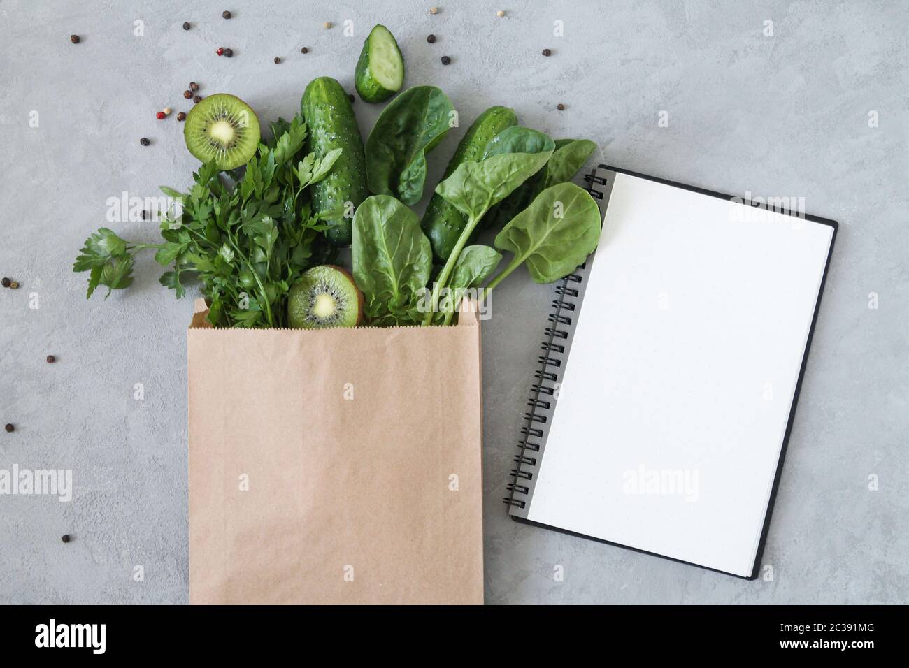 Groceries shopping paper bag with healthy green food and blank notebook ...