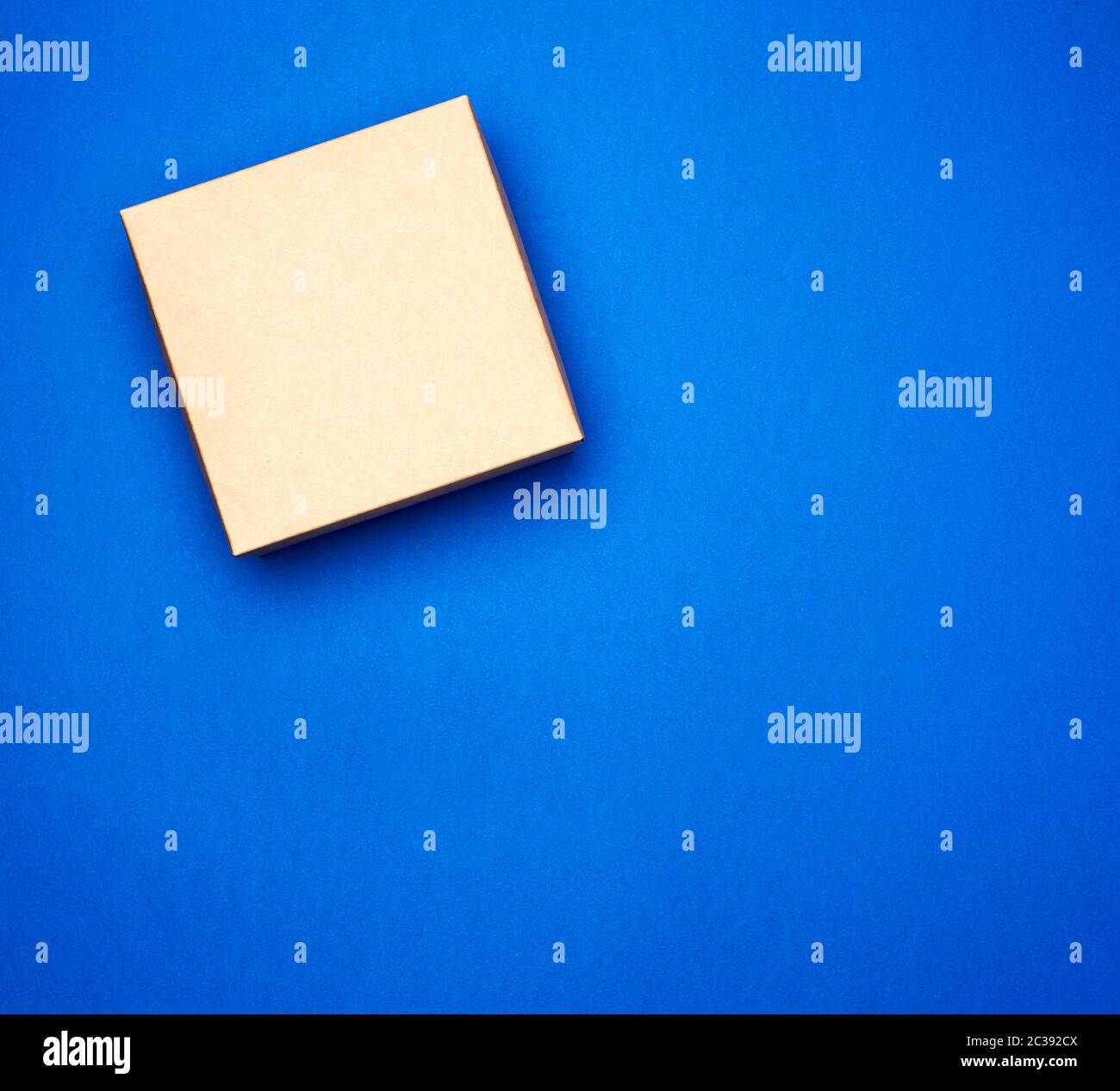 closed blue cardboard gift square box on a dark blue background, top ...