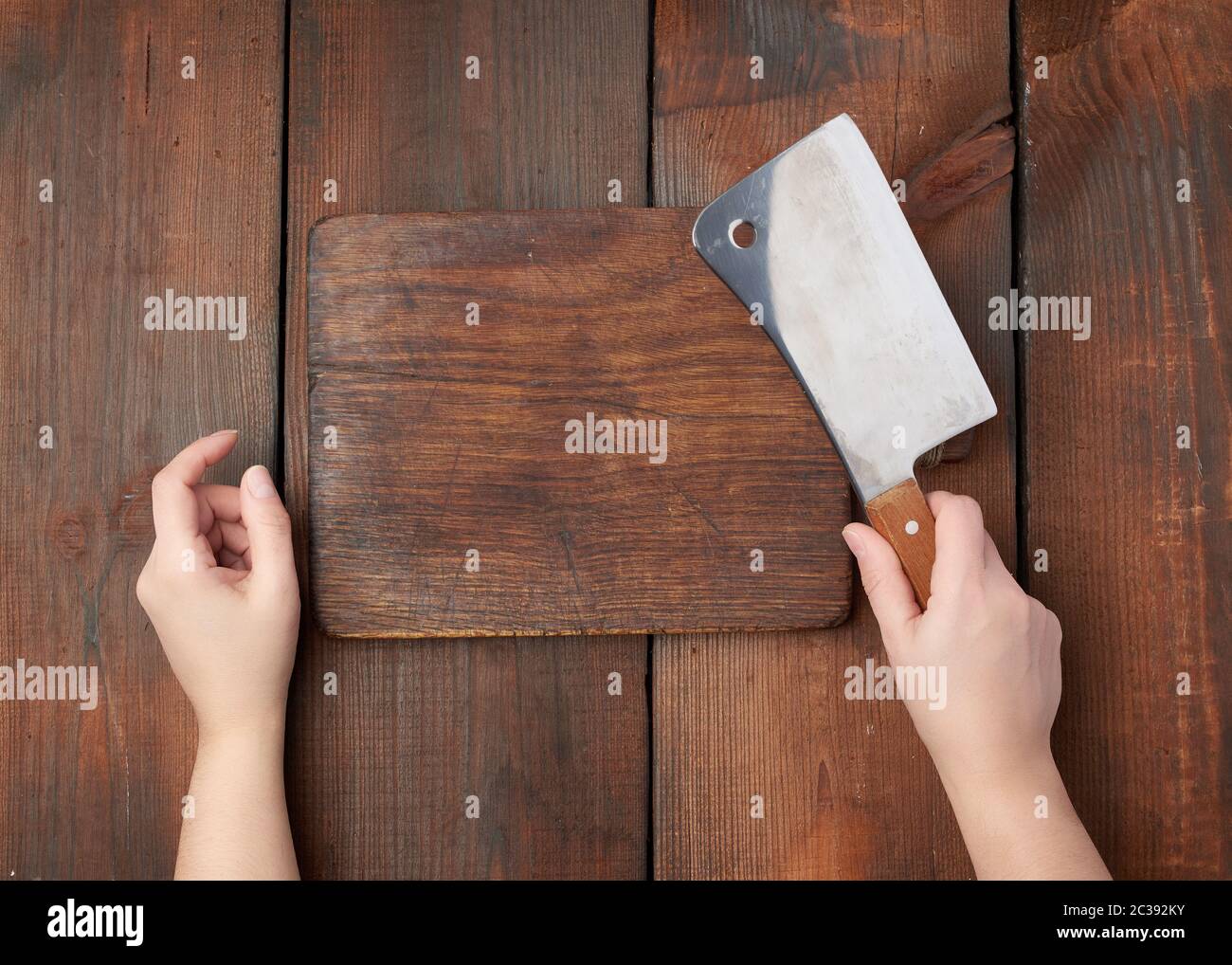very old empty wooden rectangular cutting board and hands hold a large ...