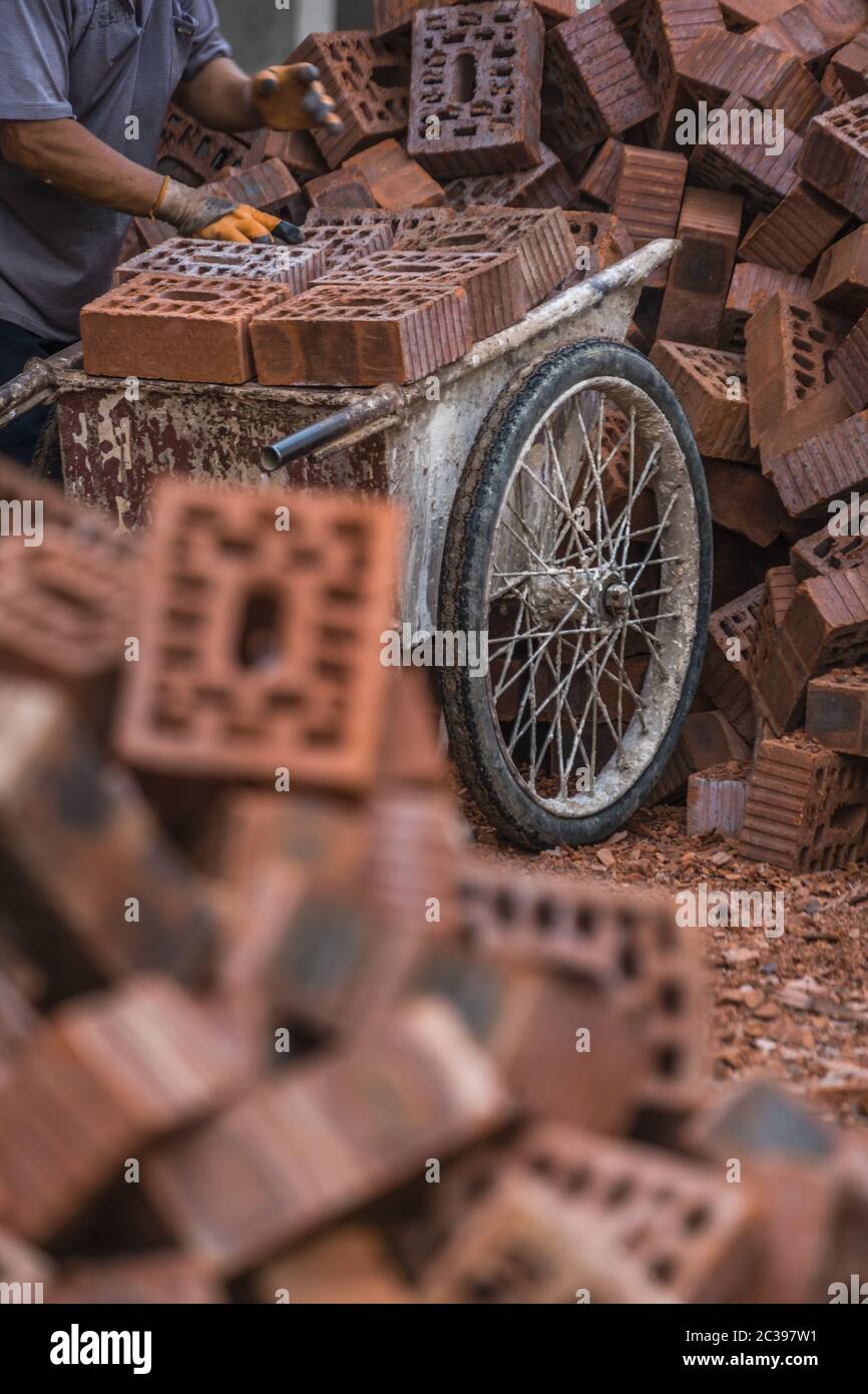 Loading bricks to trolley on the building site Stock Photo - Alamy