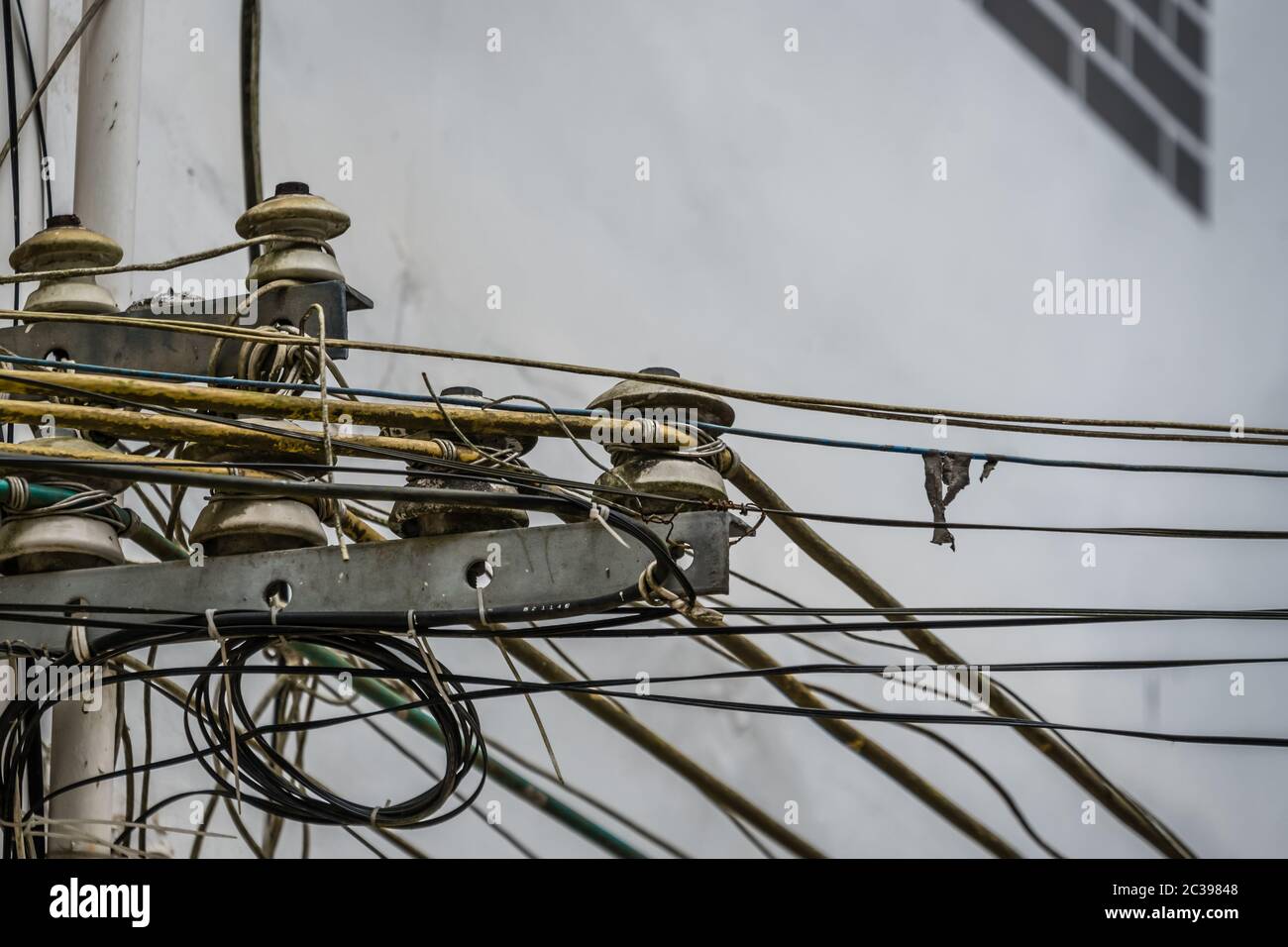Densely wired telephone and electric cables outside residential ...