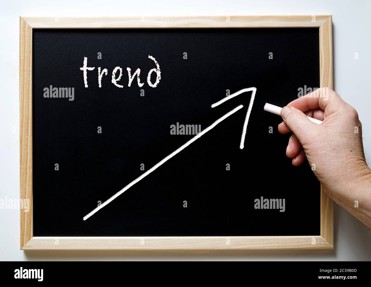 a blackboard with writing trend and an arrow indicating the rise Stock ...