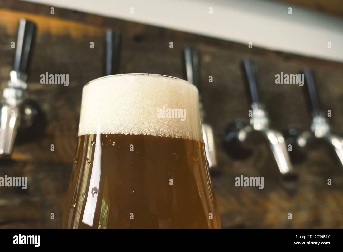 Pouring beer into a glass from the tap at the bar. Beer bottling Stock Photo - Alamy