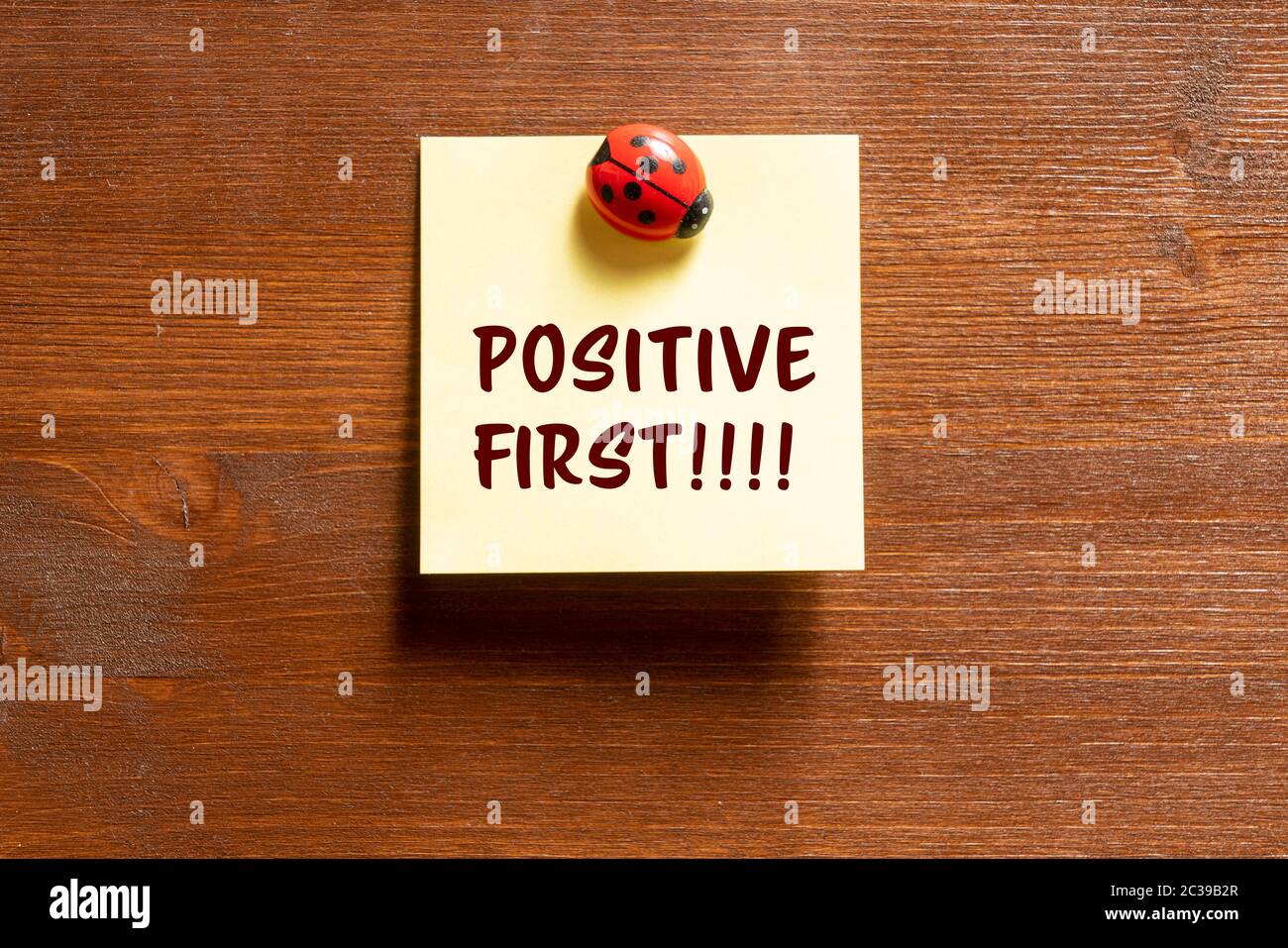 a colored memo sheet with writing positive first Stock Photo - Alamy