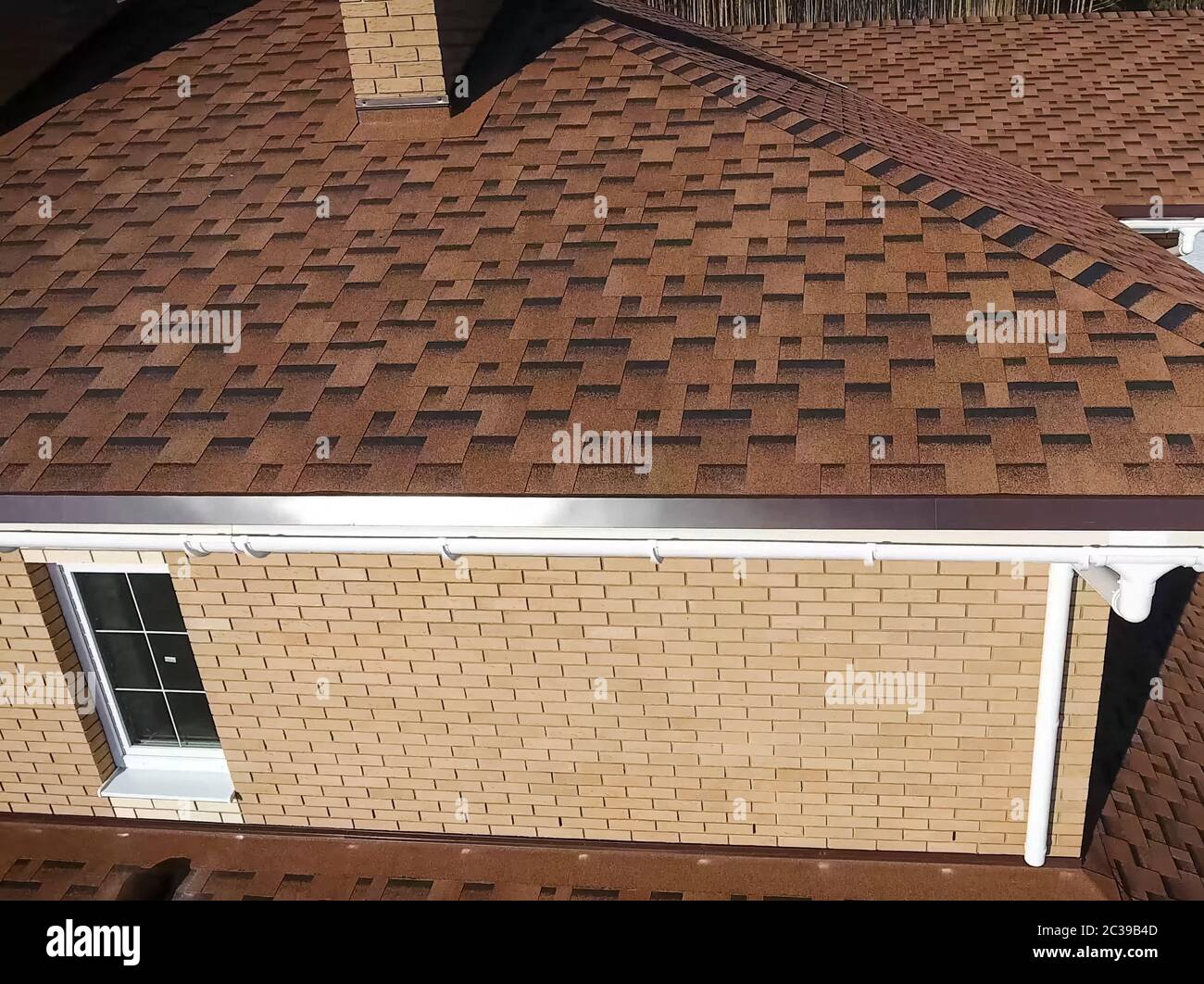 House with a roof from a bituminous tile. Bituminous tile for a roof. a ...