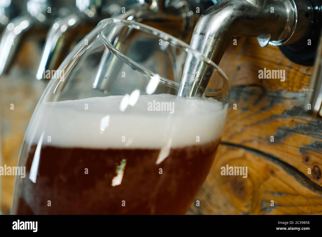Pouring beer into a glass from the tap at the bar. Beer bottling Stock Photo - Alamy