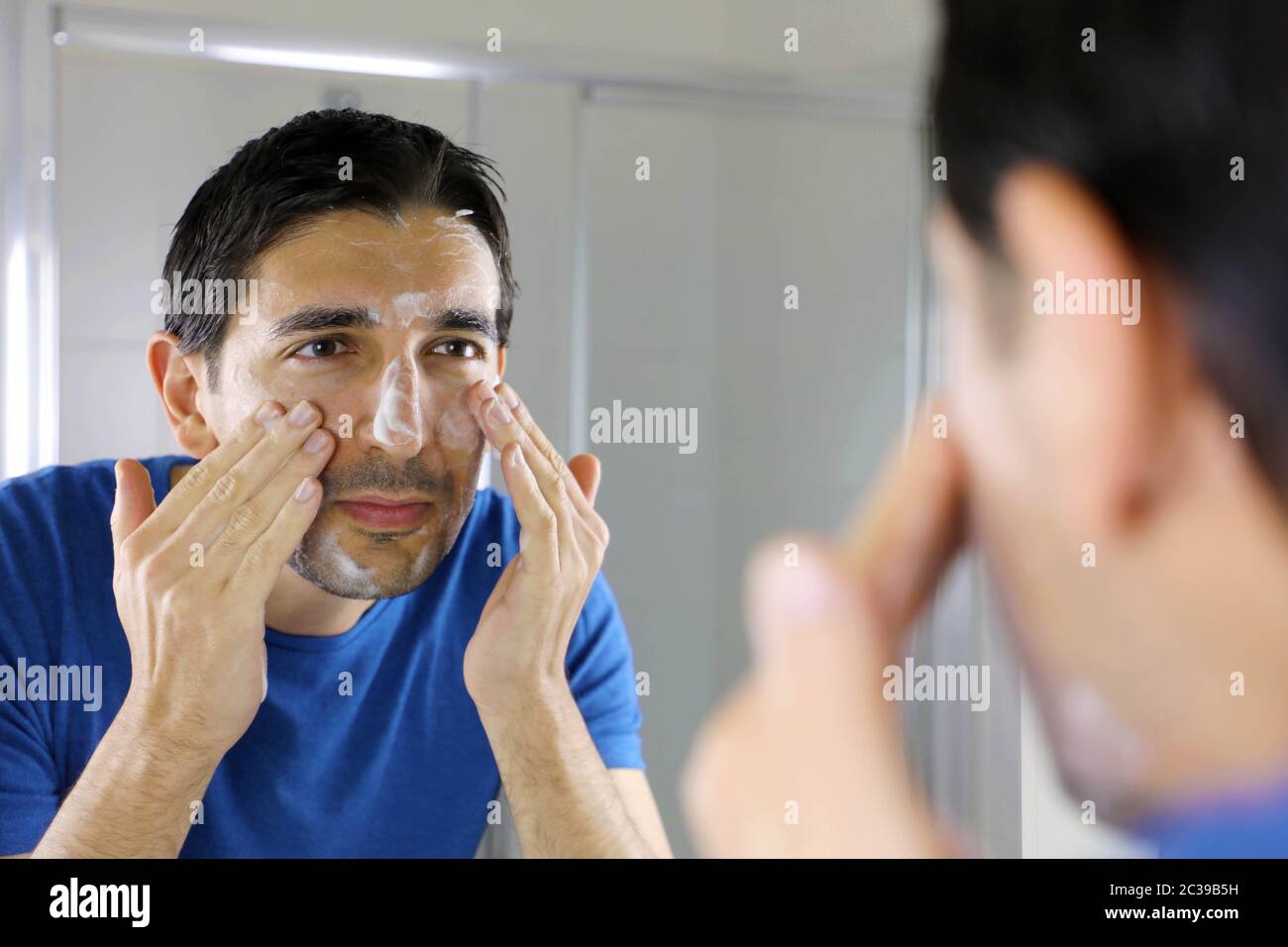 Man Washing Face With Facial Cleanser Face Wash Soap Looking At Mirror
