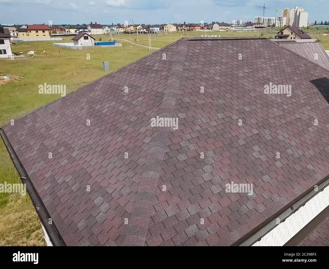 House with a roof from a bituminous tile. Bituminous tile for a roof. a ...