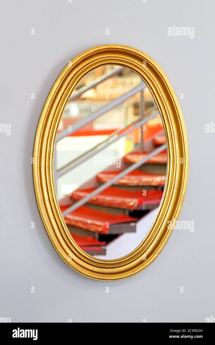 Modern decorative gold oval frame hanging on wall Stock Photo - Alamy