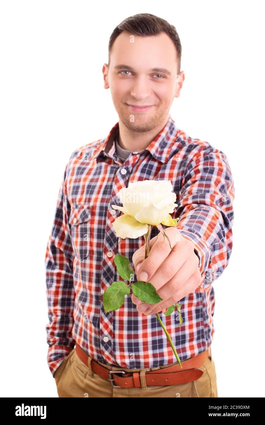 Portrait of a smiling handsome young man handing out a white rose ...