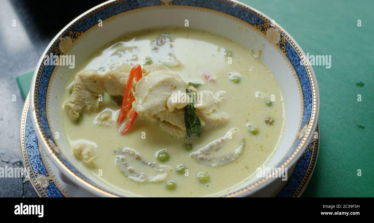 Cook green curry and pour in bowl Stock Photo - Alamy