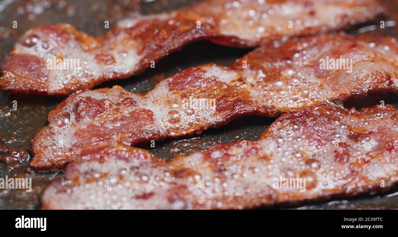 Fry bacon on a pan Stock Photo - Alamy