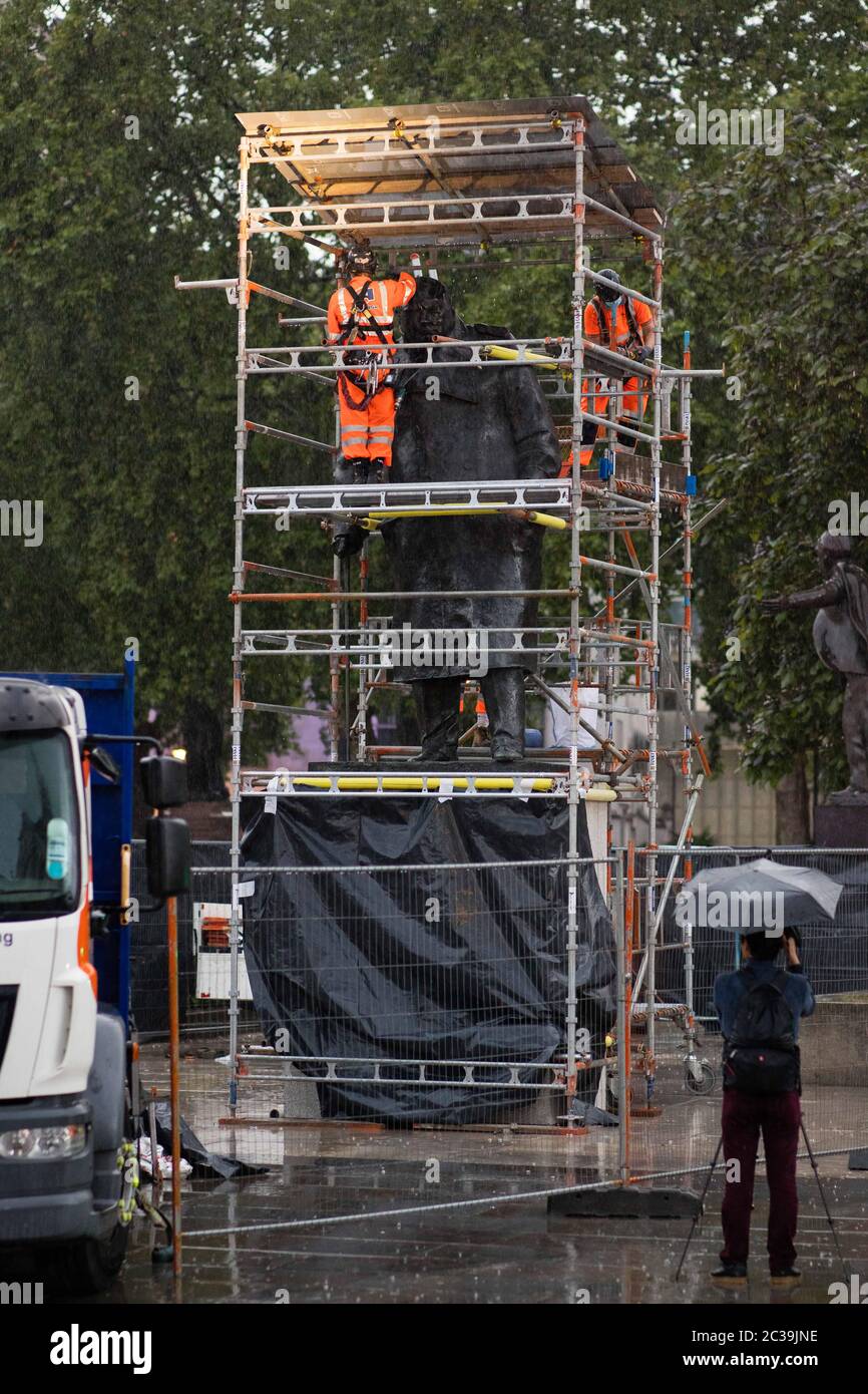 Workmen remove the protective box from around the statue of Winston ...