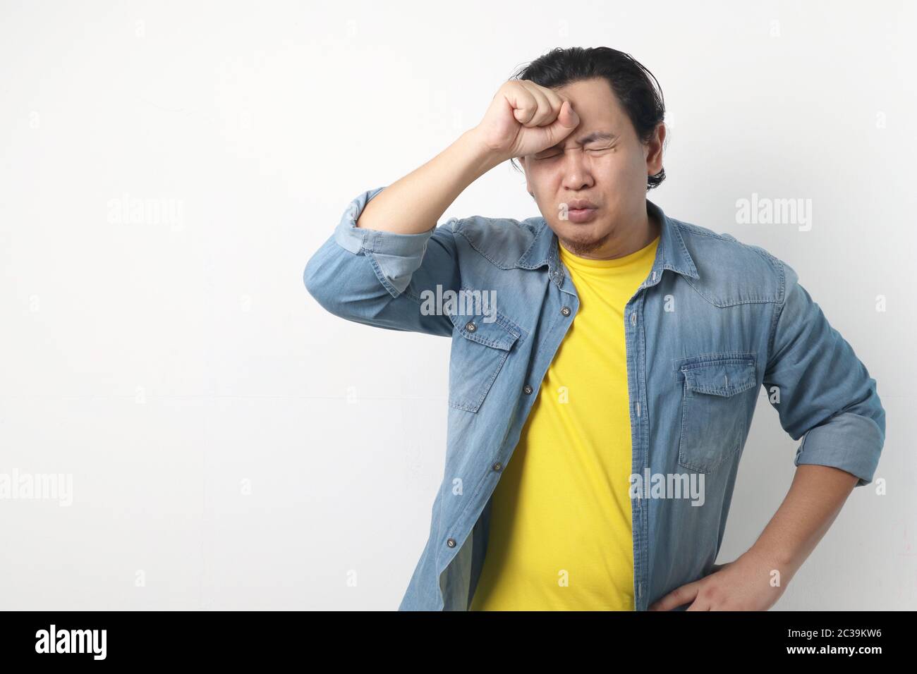 Asian man shows regret gesture, hits his forehead, agains white ...