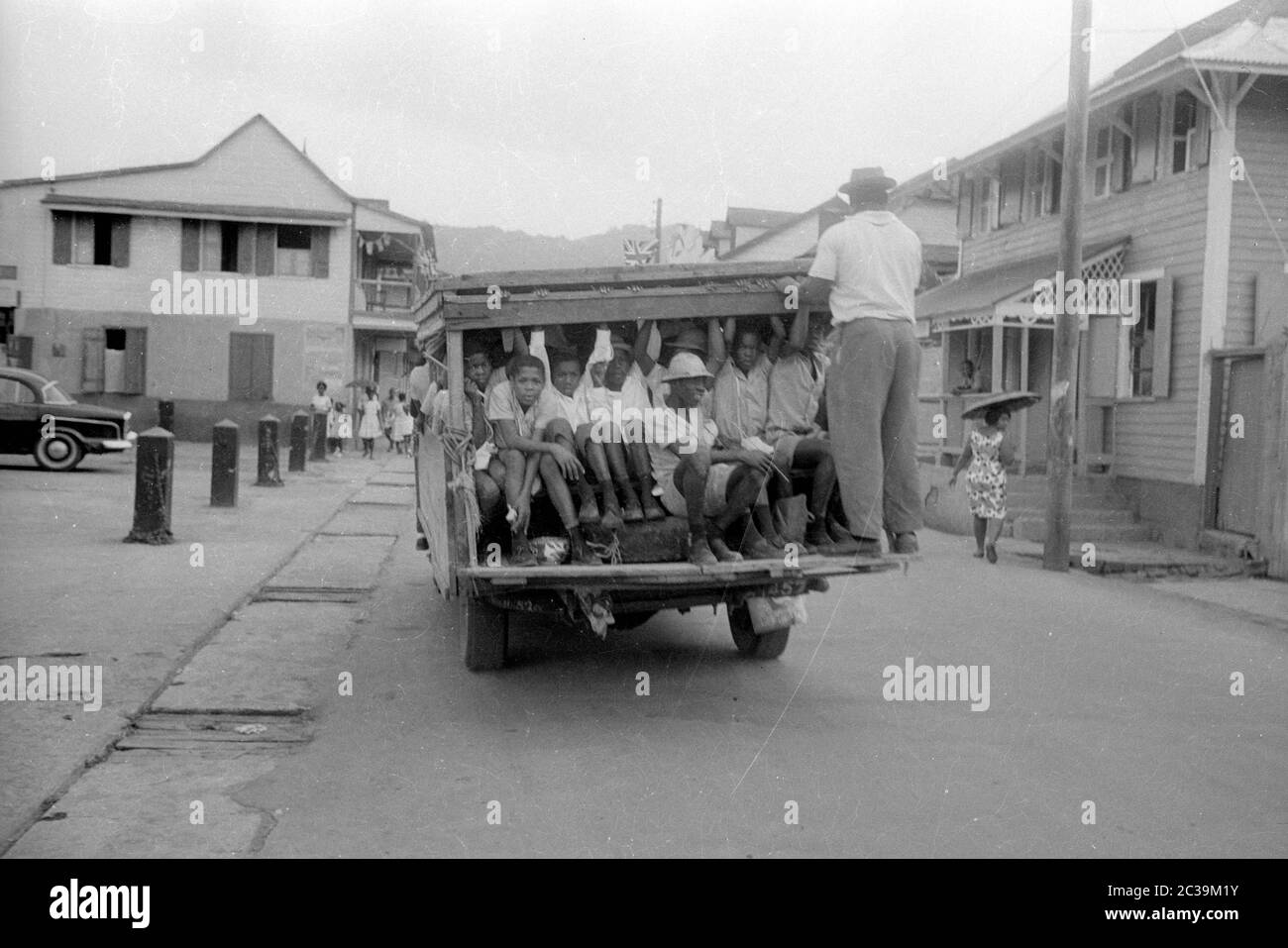 Residents of the Caribbean island of Antigua sit crowded on a van Stock ...