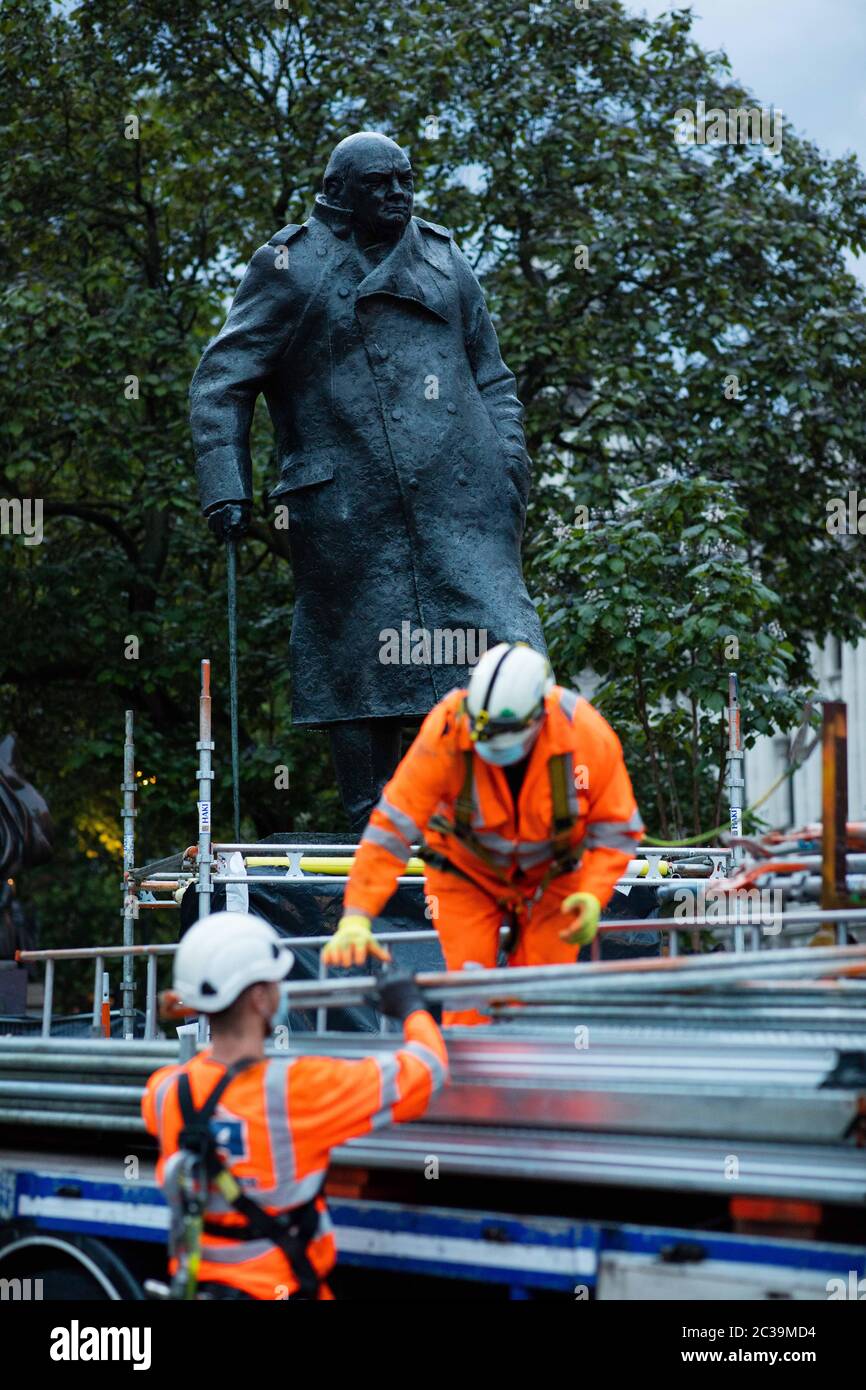 Workmen remove the protective box from around the statue of Winston ...