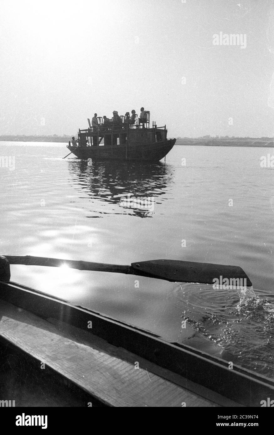 European visitors on wooden rowing boats on the Ganges in the north ...