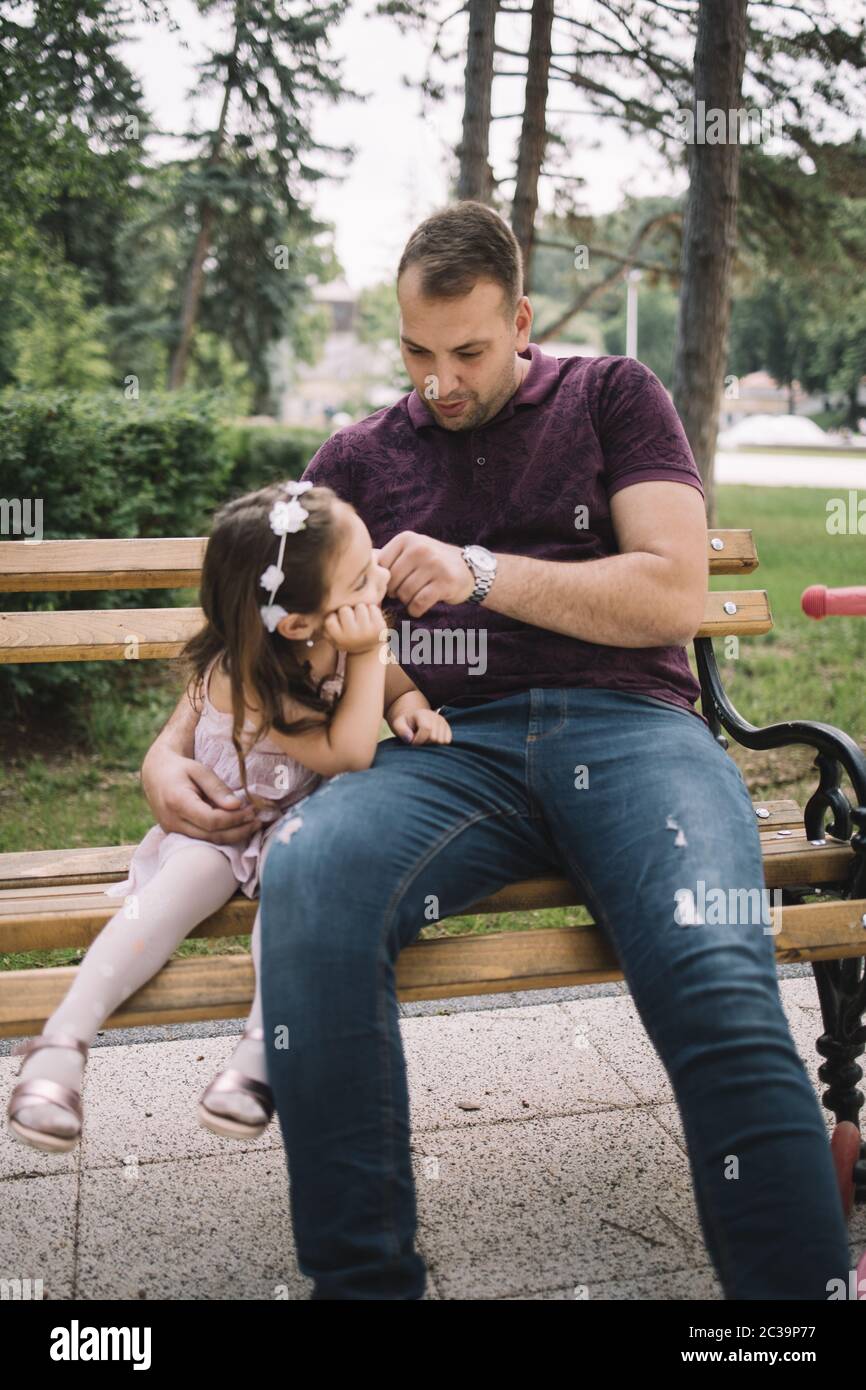 Man pinching little girls cheek while resting on bench Stock Photo - Alamy
