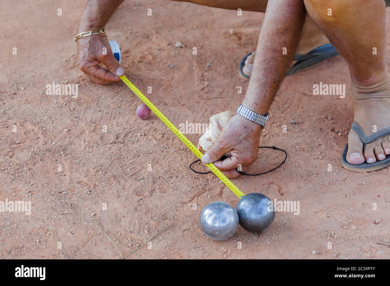 Man measures distance between balls during petanque game Stock Photo ...