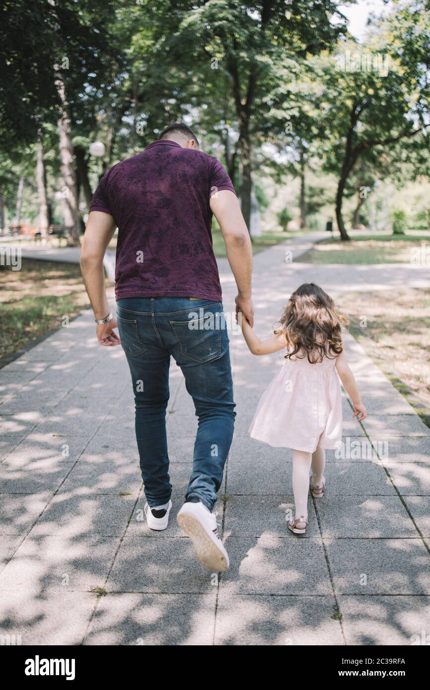 Back view of father and daughter walking Stock Photo - Alamy