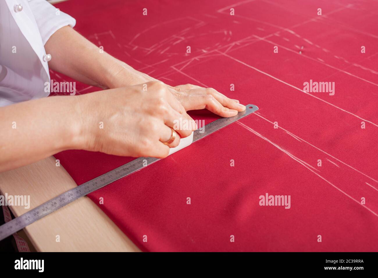 A beautiful seamstress woman in her own atelier makes a pattern on the ...