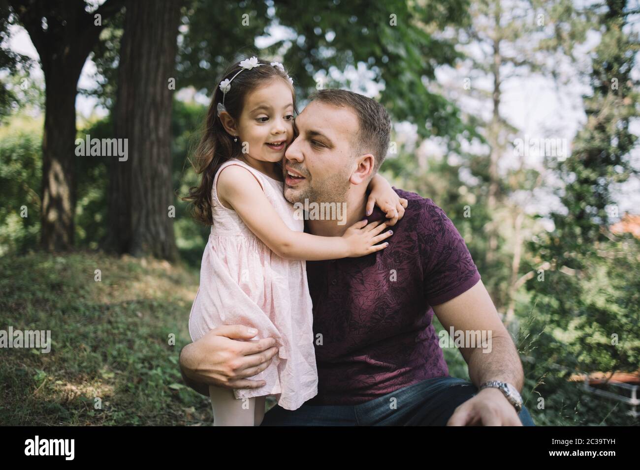 Portrait of daughter hugging her father in park Stock Photo - Alamy
