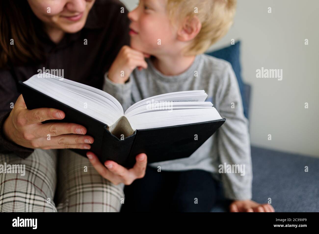 Mother and child reading book and smiling. Happy family time together ...
