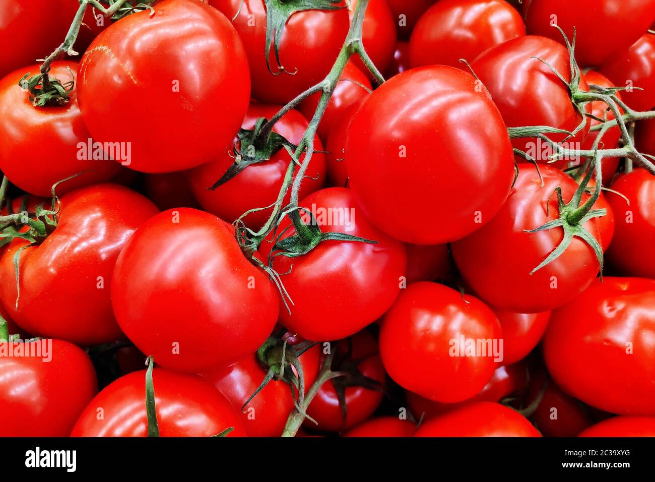 Close-up on a stack of round tomatoes in bunched on a market stall ...