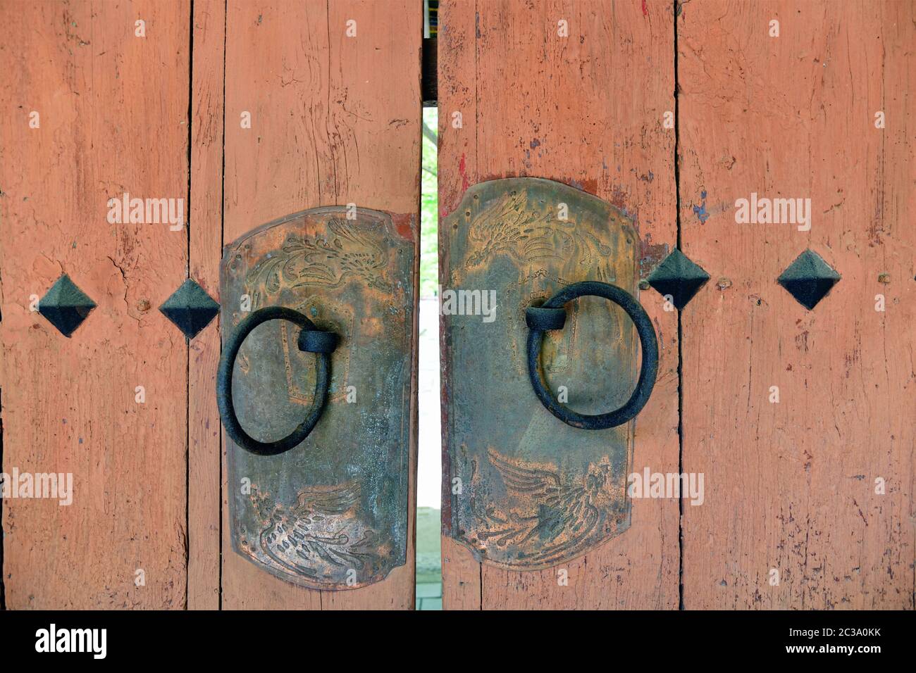 Ancient gates with door handles and copper plates engraved in the shape ...