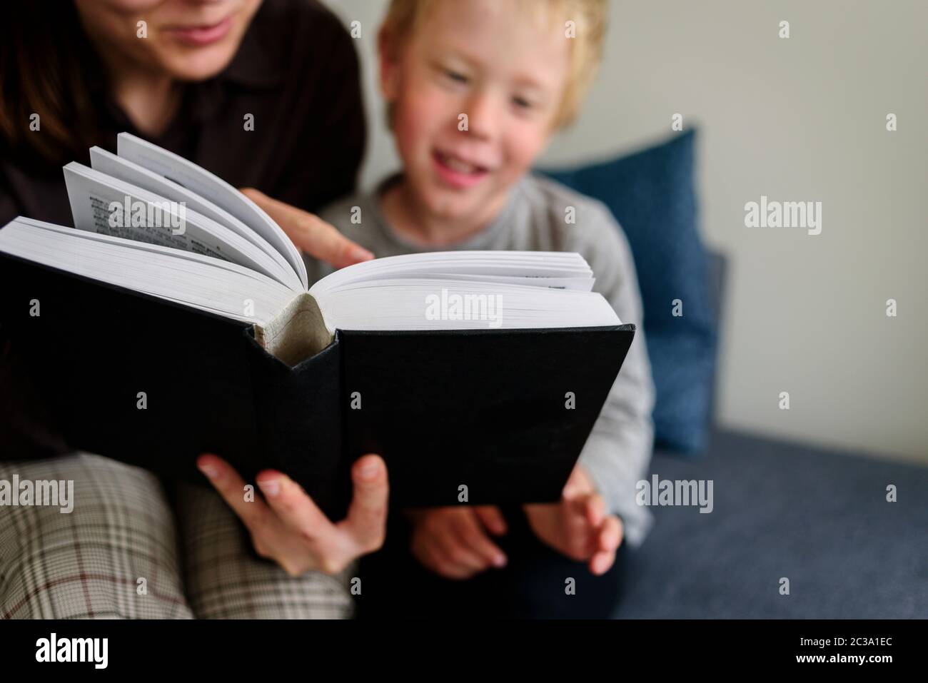 Mother and child reading book and smiling. Happy family time together ...
