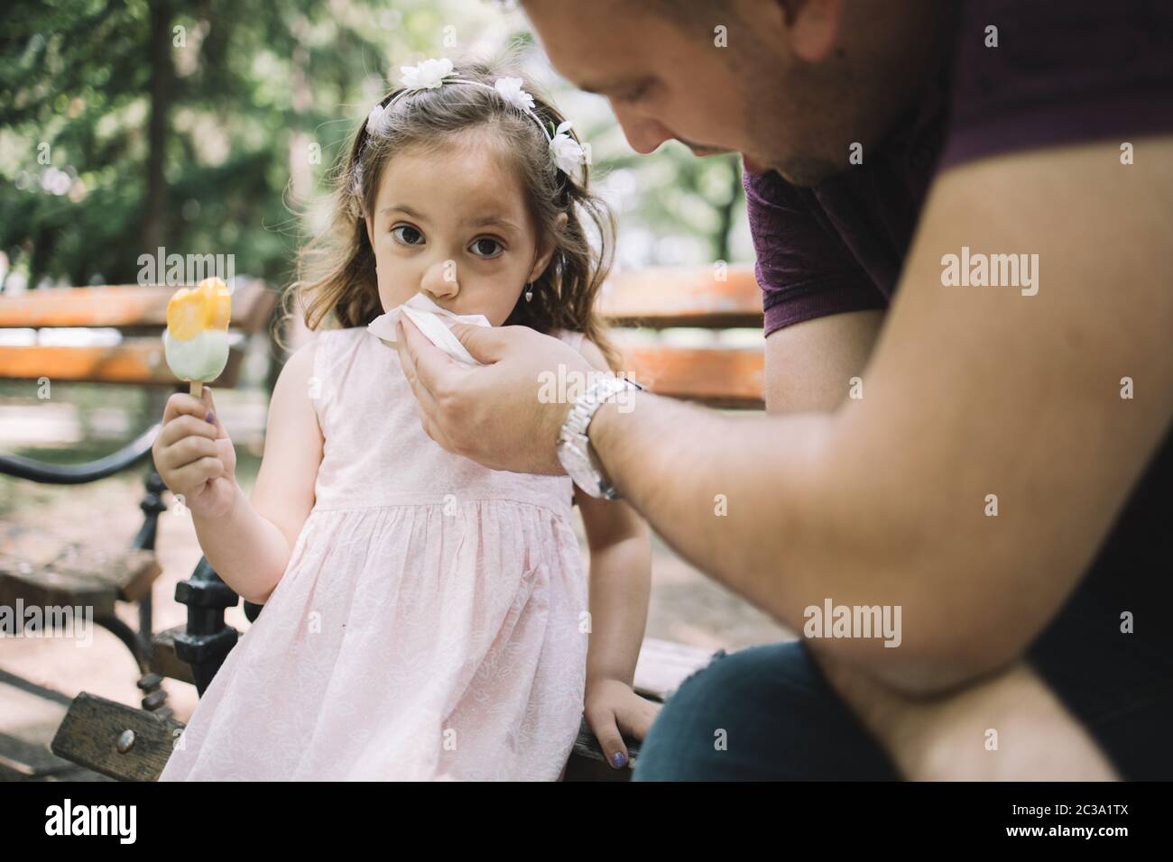 Dad using napkin to clean his daughter's face Stock Photo - Alamy