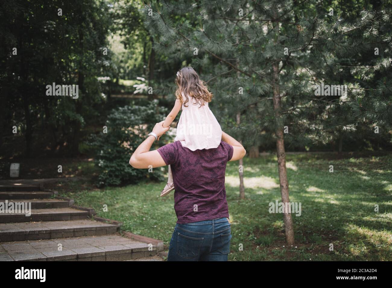 Back view of father having daughter on his shoulders Stock Photo - Alamy