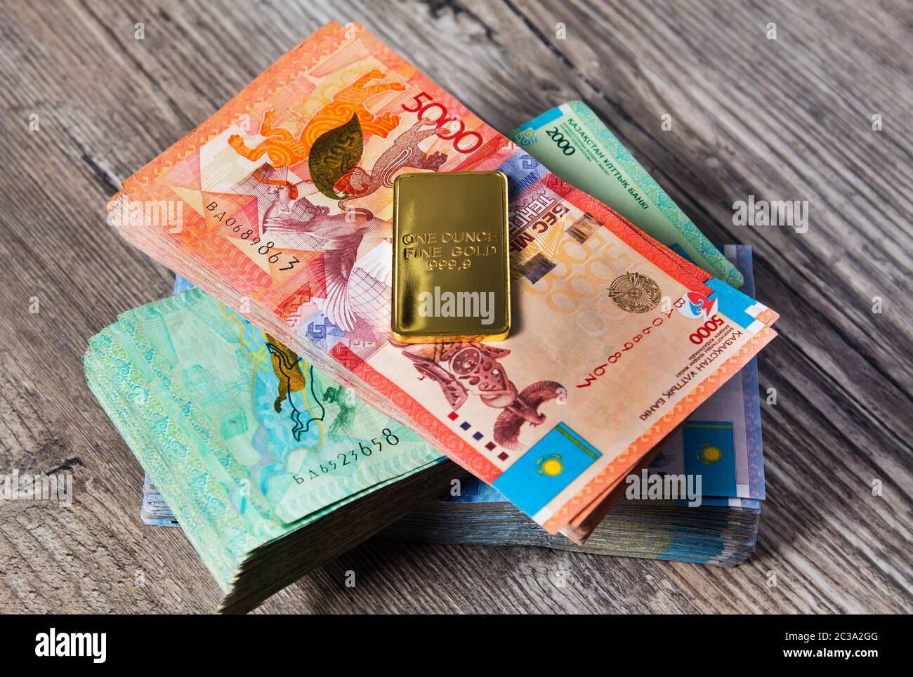 Paper banknotes tenge KZT with gold ingot. Tenge is the national ...