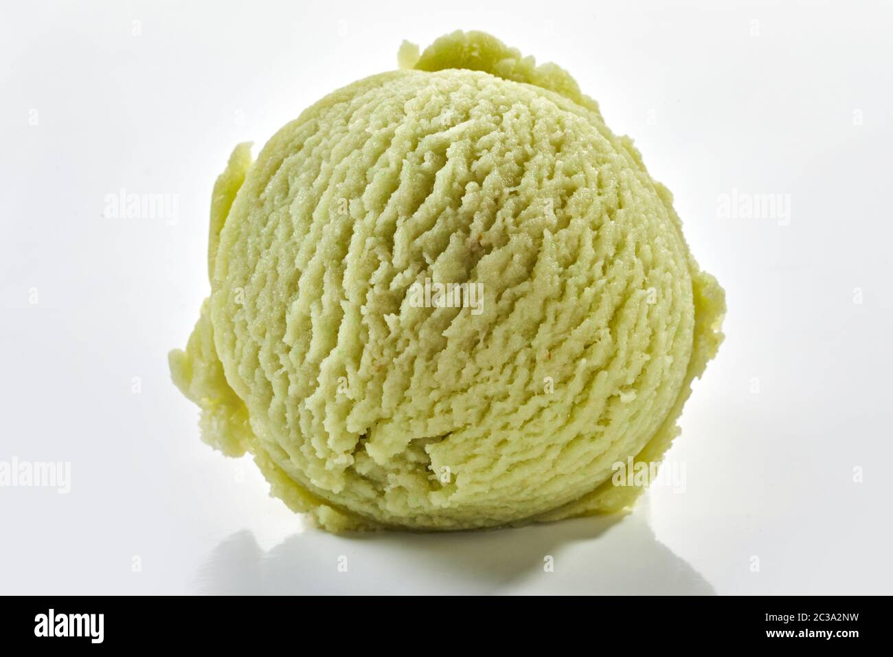 Close-up on one round green scoop of herbal ice cream on white ...