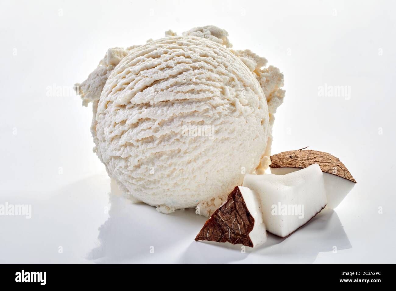 Scoop of ice cream with coconut pulp in close-up on white background ...