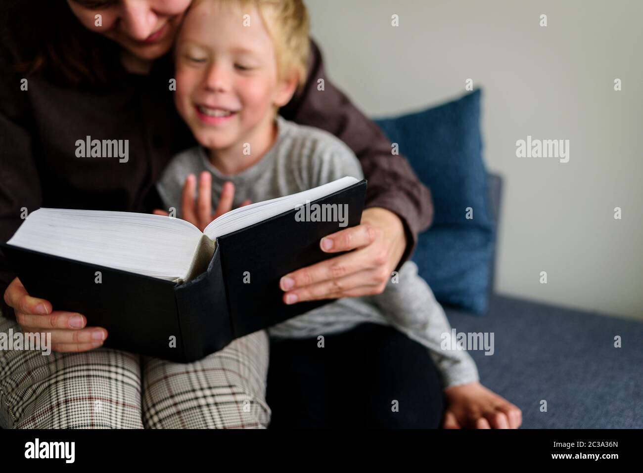 Mother and child reading book and smiling. Happy family time together ...