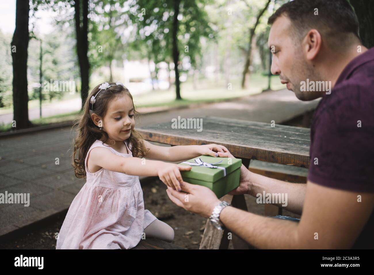 Little child receiving present from father outdoor Stock Photo - Alamy