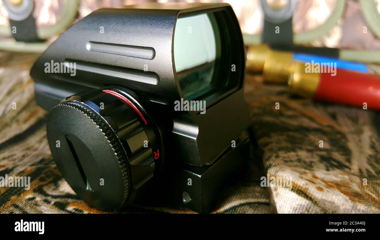 red dot sight and ammunition on camouflage background, wallpaper Stock ...