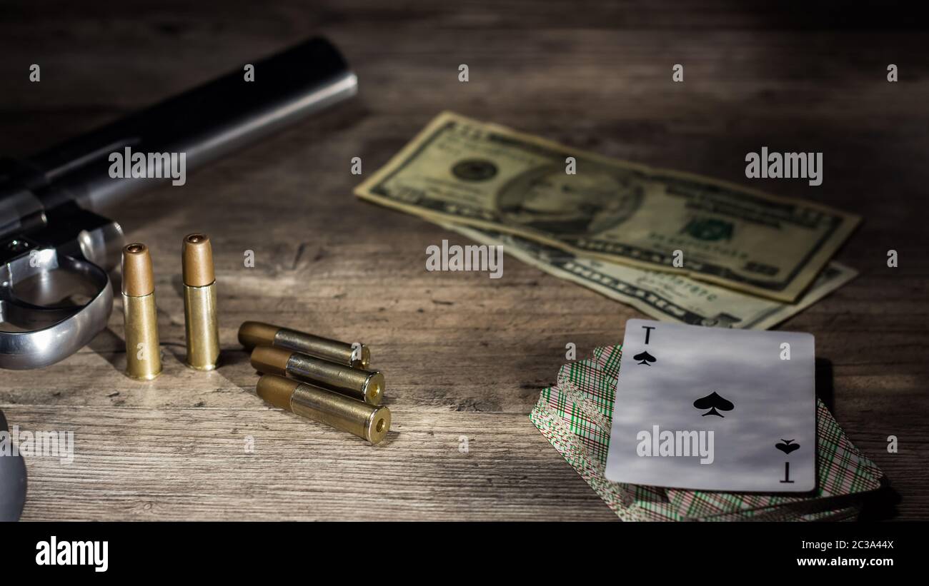 Dangerous gambling for money. A pistol with cartridges, money dollars ...