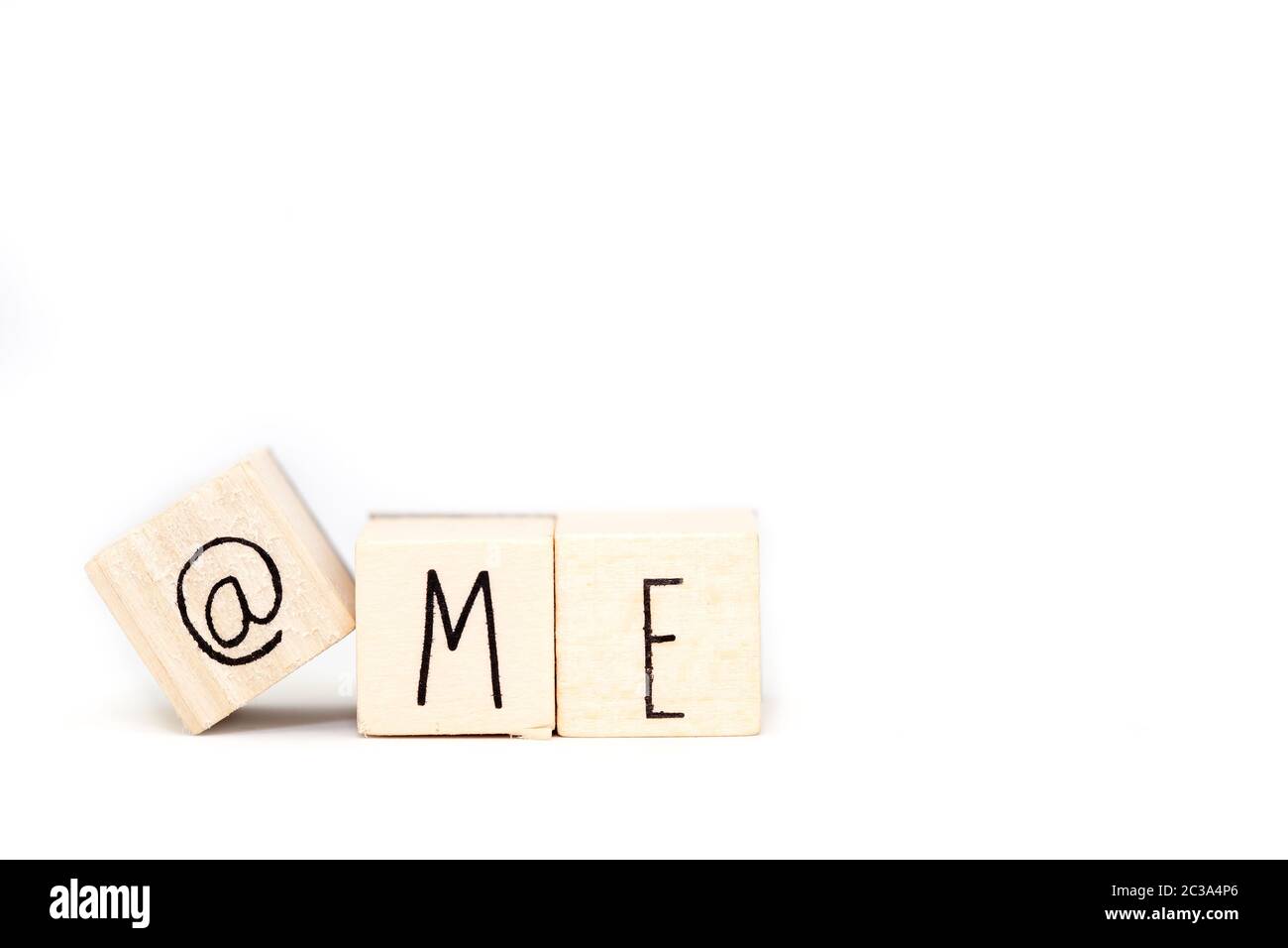 Wooden cube with a commercial At Sign symbol and the word Me isolated ...