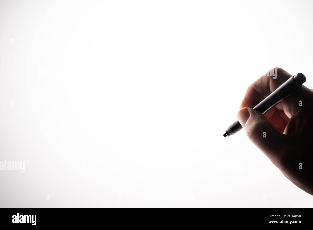 one hand writes with the pen on a backlit surface Stock Photo - Alamy