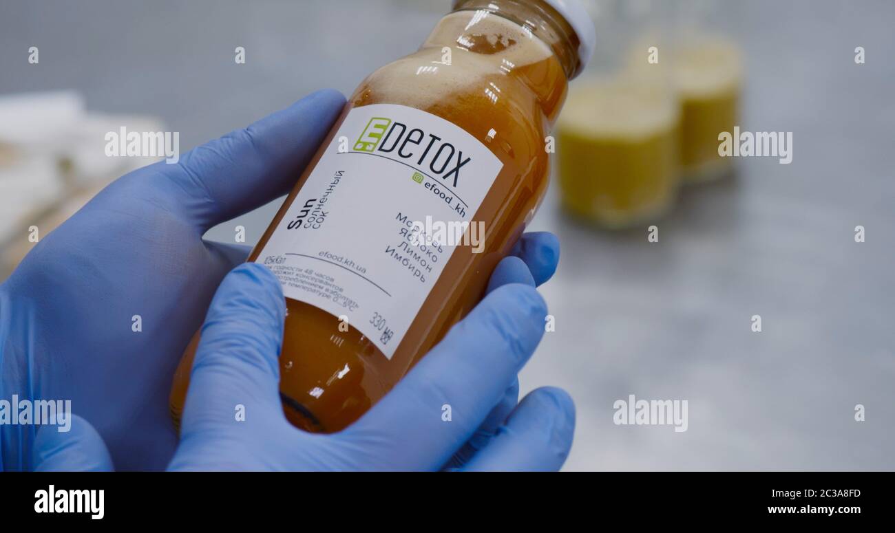 Man sticking label on bottle with detox drink, close up Stock Photo - Alamy