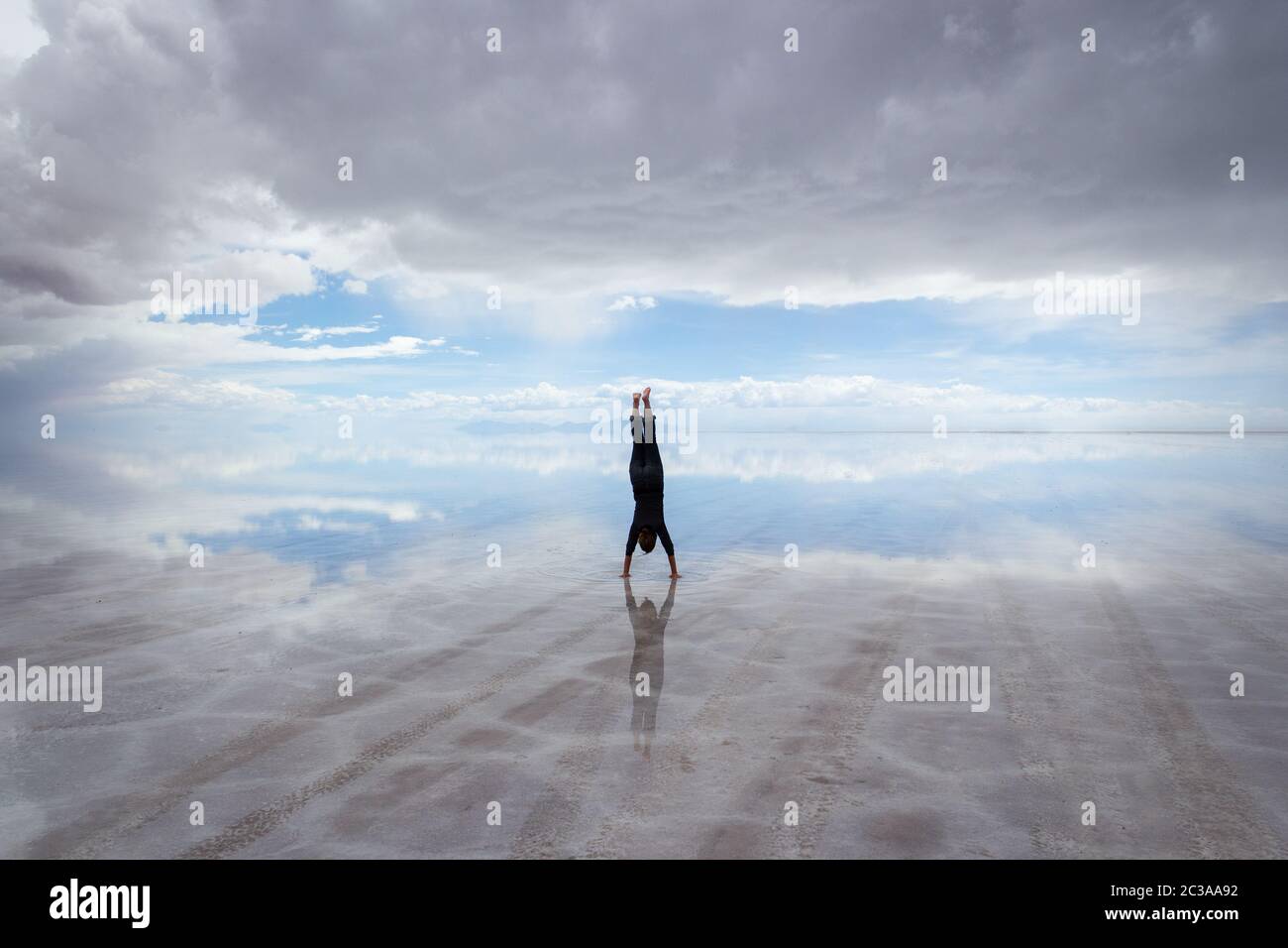 Happy, joyful woman doing handstand, salt flats, Salar de Uyuni ...