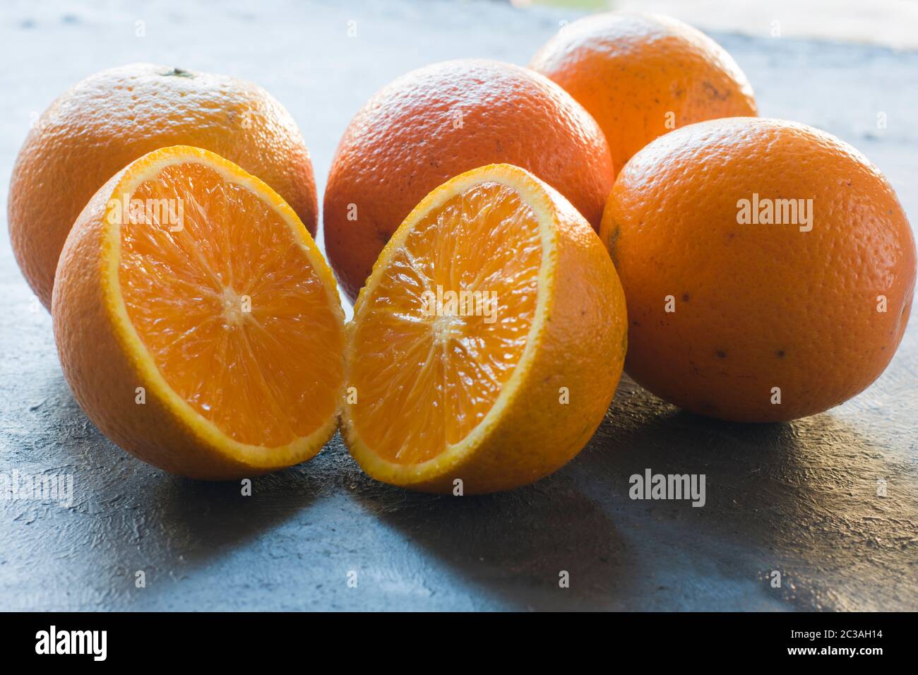 A group of oranges and one orange cut. Healthy fruit Stock Photo - Alamy
