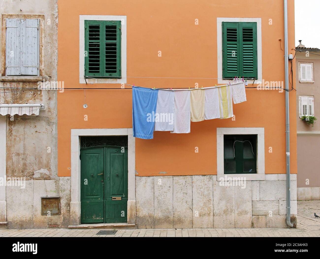 Wet laundry drying on a string on facade of retro house Stock Photo - Alamy