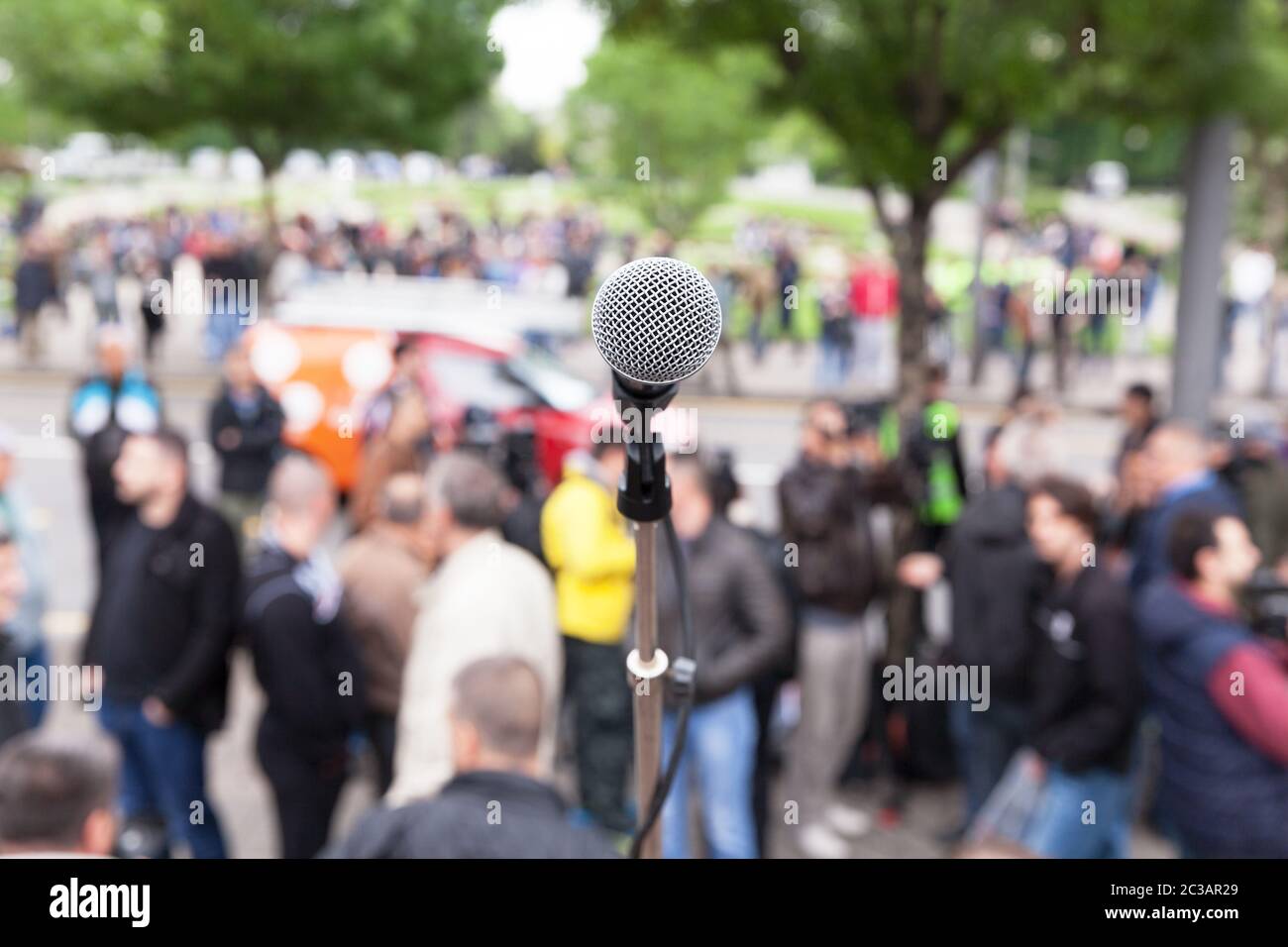 Street protest. Public demonstration. Microphone in focus against ...