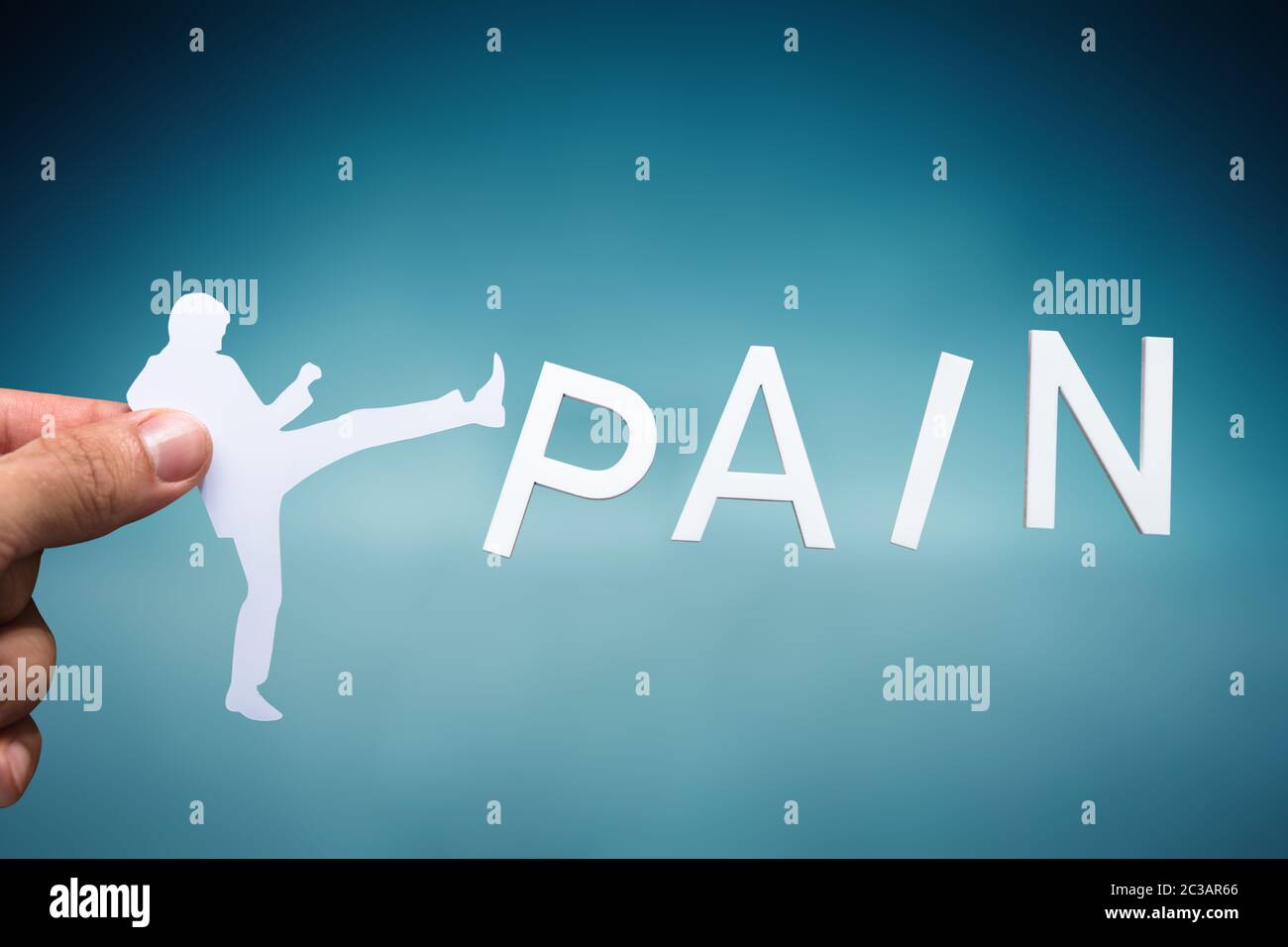 Human Hand Holding White Cut Out Human Figure Kicking White Pain Word ...