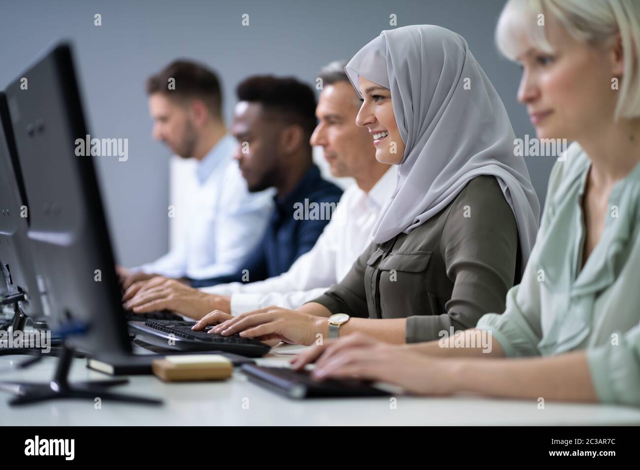 Group Of Young Businesspeople Working On Computer Stock Photo - Alamy