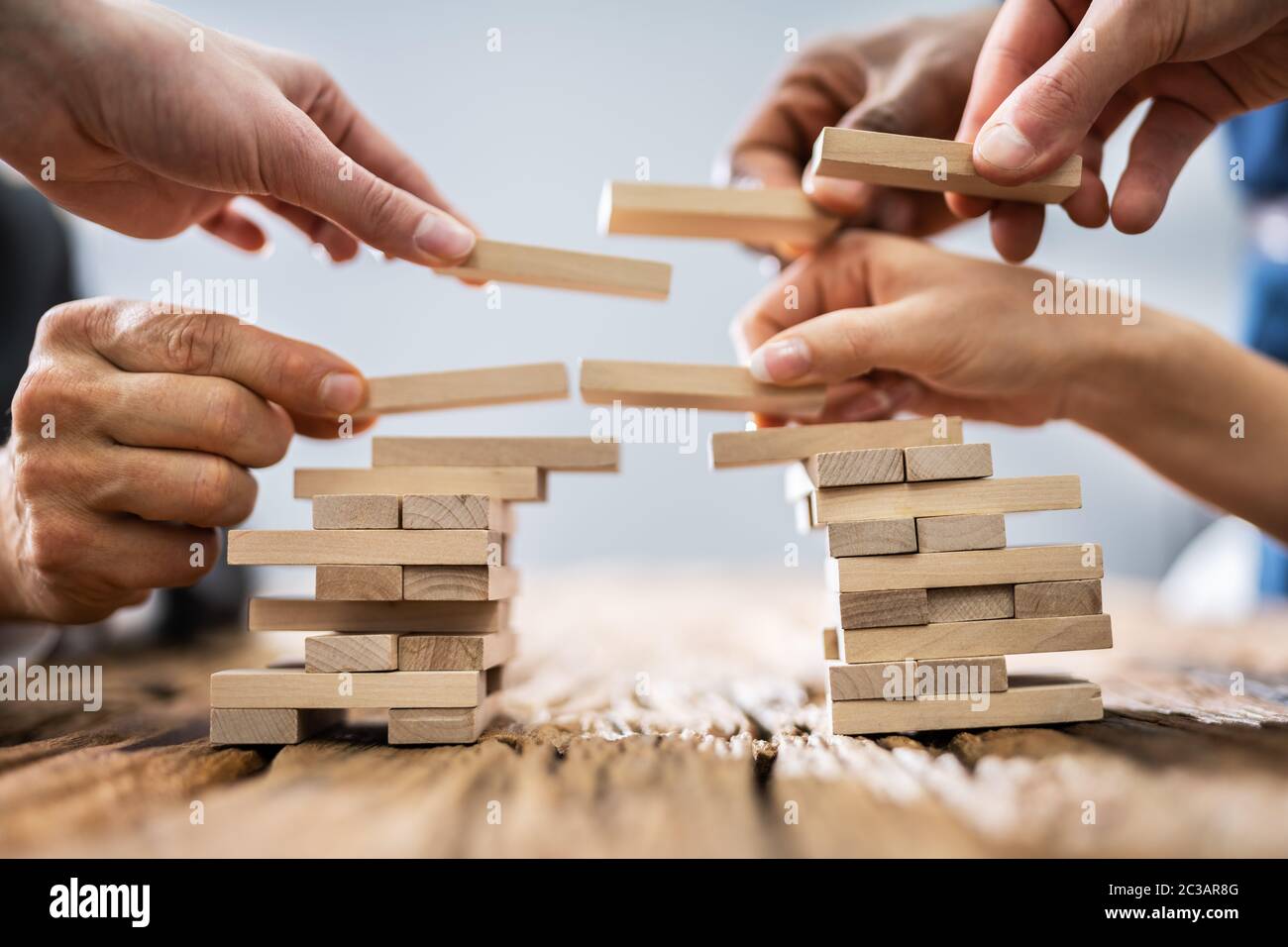 Close-up Of Human's Hand Placing Wooden Block Over Desk Stock Photo - Alamy