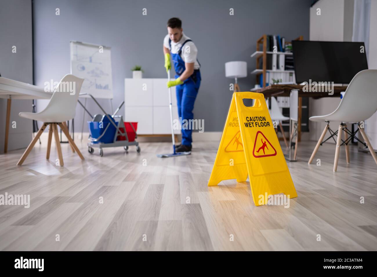 Close-up Of Man Cleaning The Floor With Yellow Wet Floor Sign Stock ...